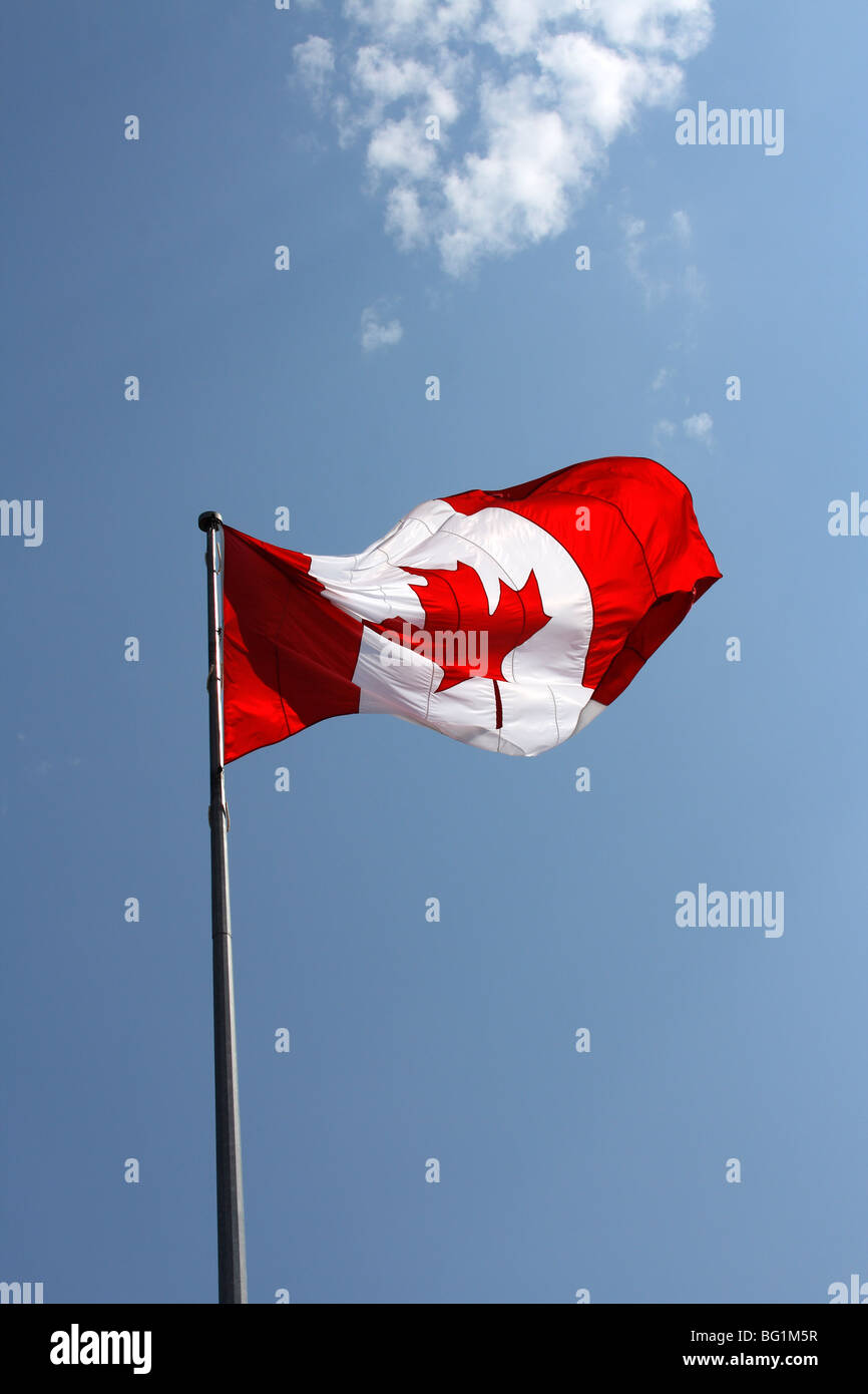 big Canadian flag high on the bright blue sky Stock Photo - Alamy