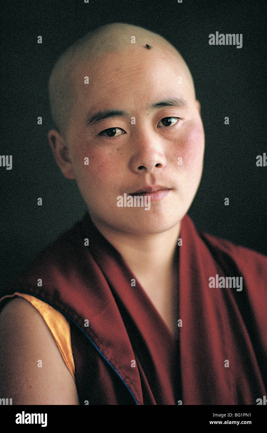 A portrait of a Tibetan Buddhist nun with a fly on her forehead in ...