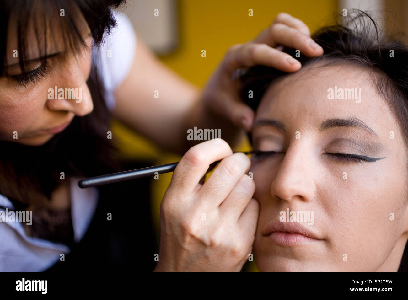 Young attractive model getting her face make up applied for a fashion ...