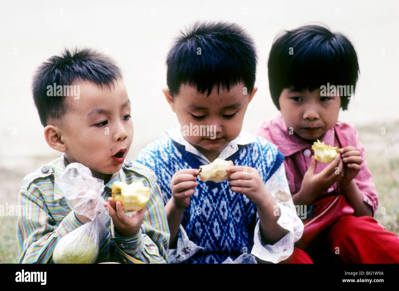 Three Chinese children eating pear apples in Guangzhou, China Stock ...