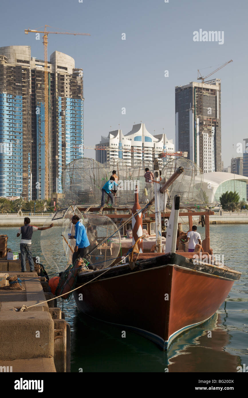 Fishermen loading dhow with baskets at Port Zayed, Abu Dhabi with new ...
