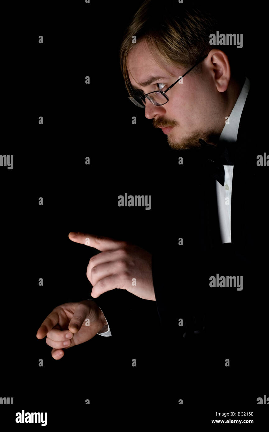 Choir conductor wearing a black tuxedo, photo on black background Stock ...