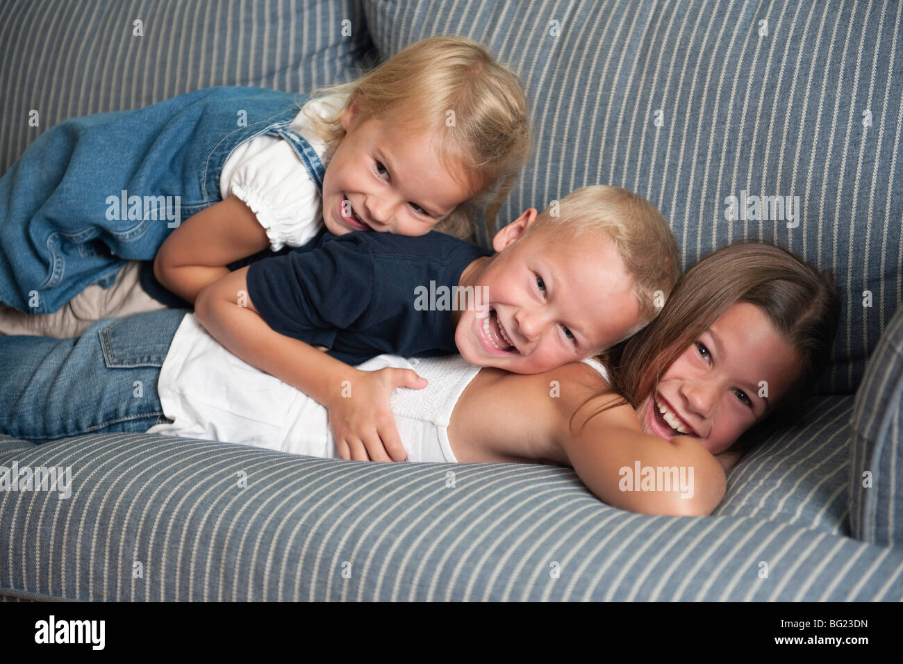 Siblings together on couch Stock Photo - Alamy