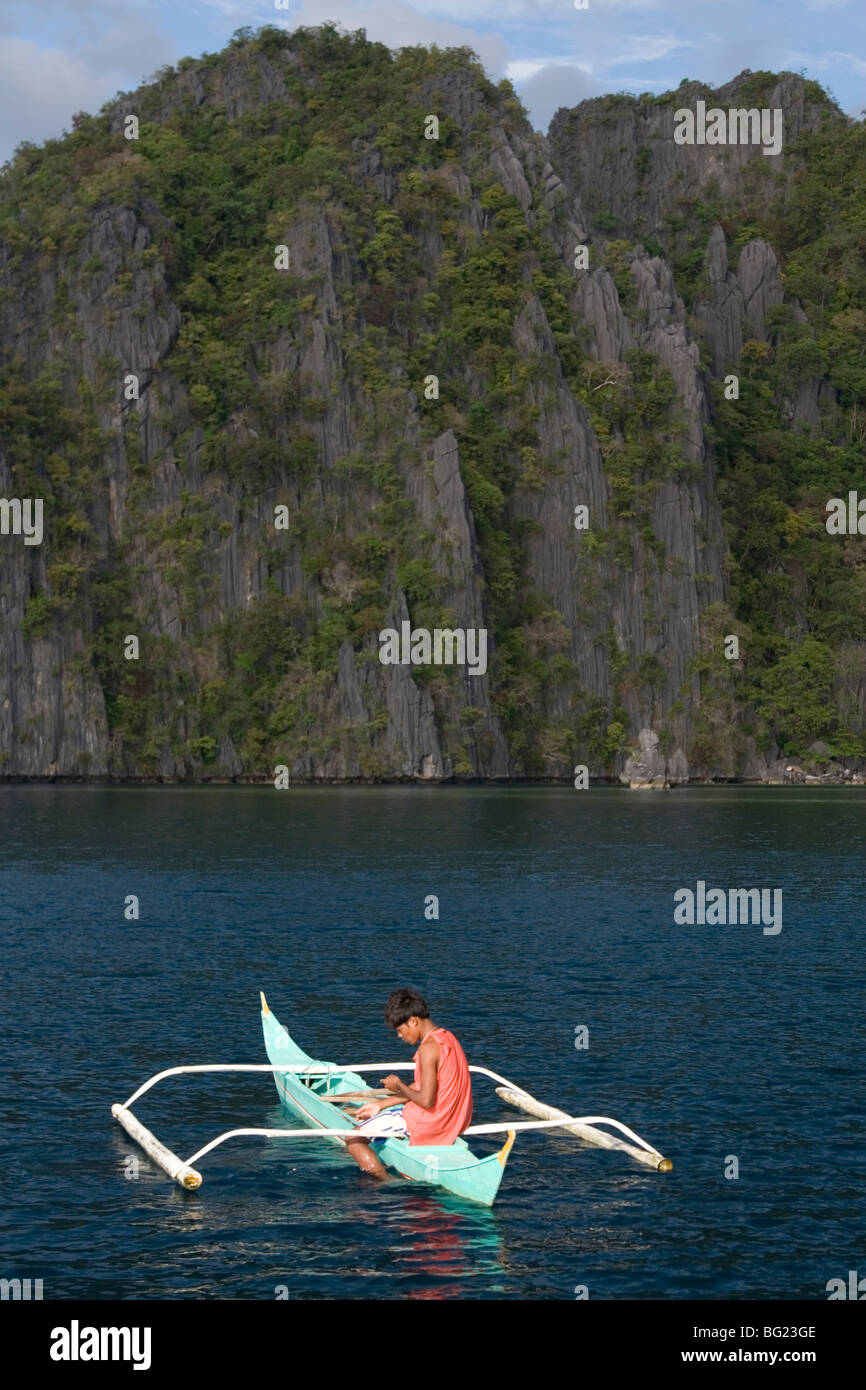 A fisherman in his outrigger boat fishing off Coron Island in the ...