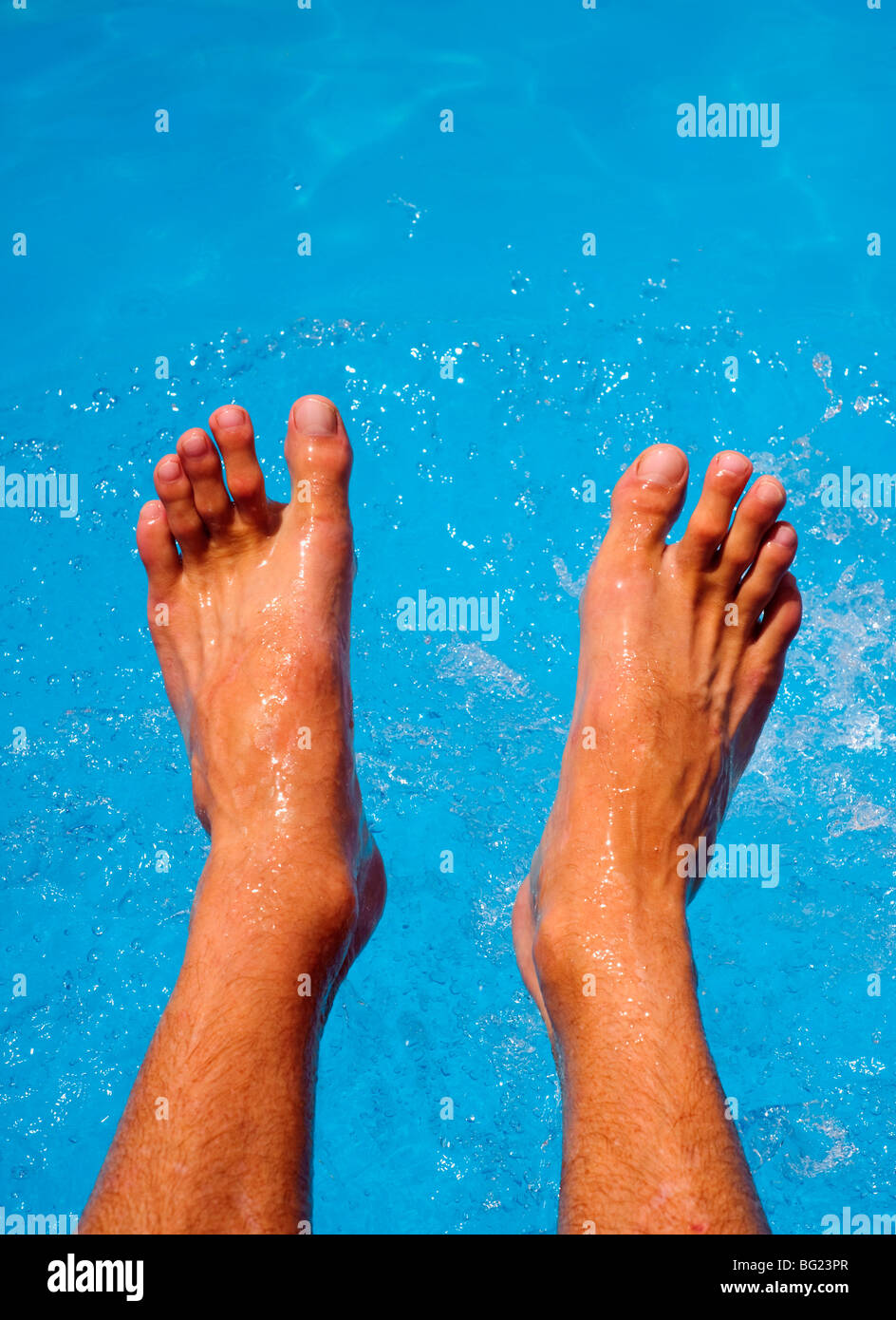 Bare feet splashing in a pool Stock Photo - Alamy