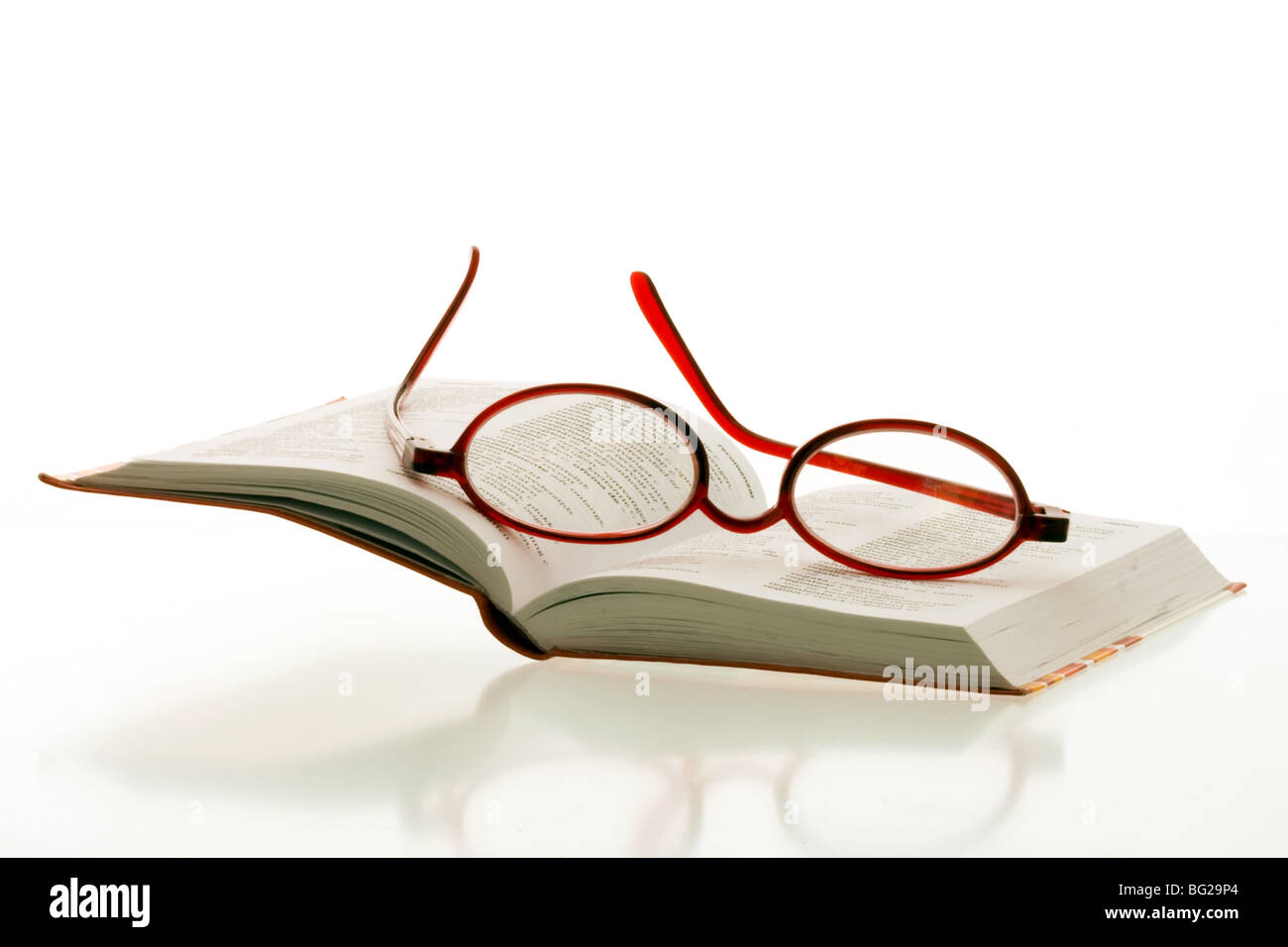 red reading glasses on the pages of an open book Stock Photo - Alamy