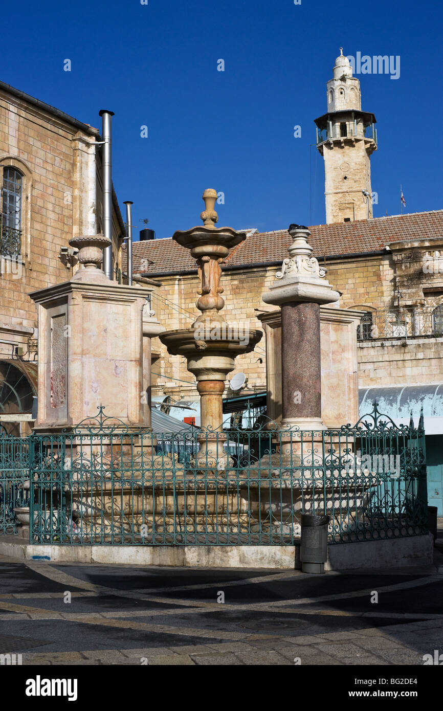 Fountain at small square in the Old City of Jerusalem and minaret ...