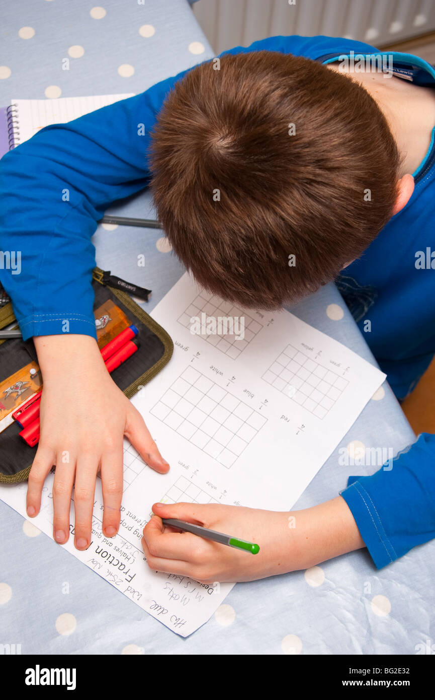 A MODEL RELEASED picture of a ten year old boy doing his maths homework ...