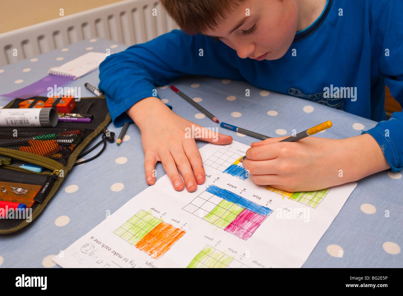 A MODEL RELEASED picture of a ten year old boy doing his maths homework ...