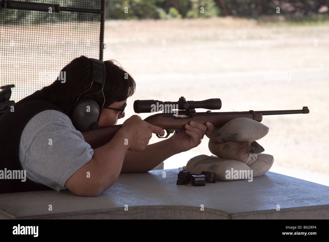 Man looking through scope on Ruger 10/22 rifle while practicing target ...