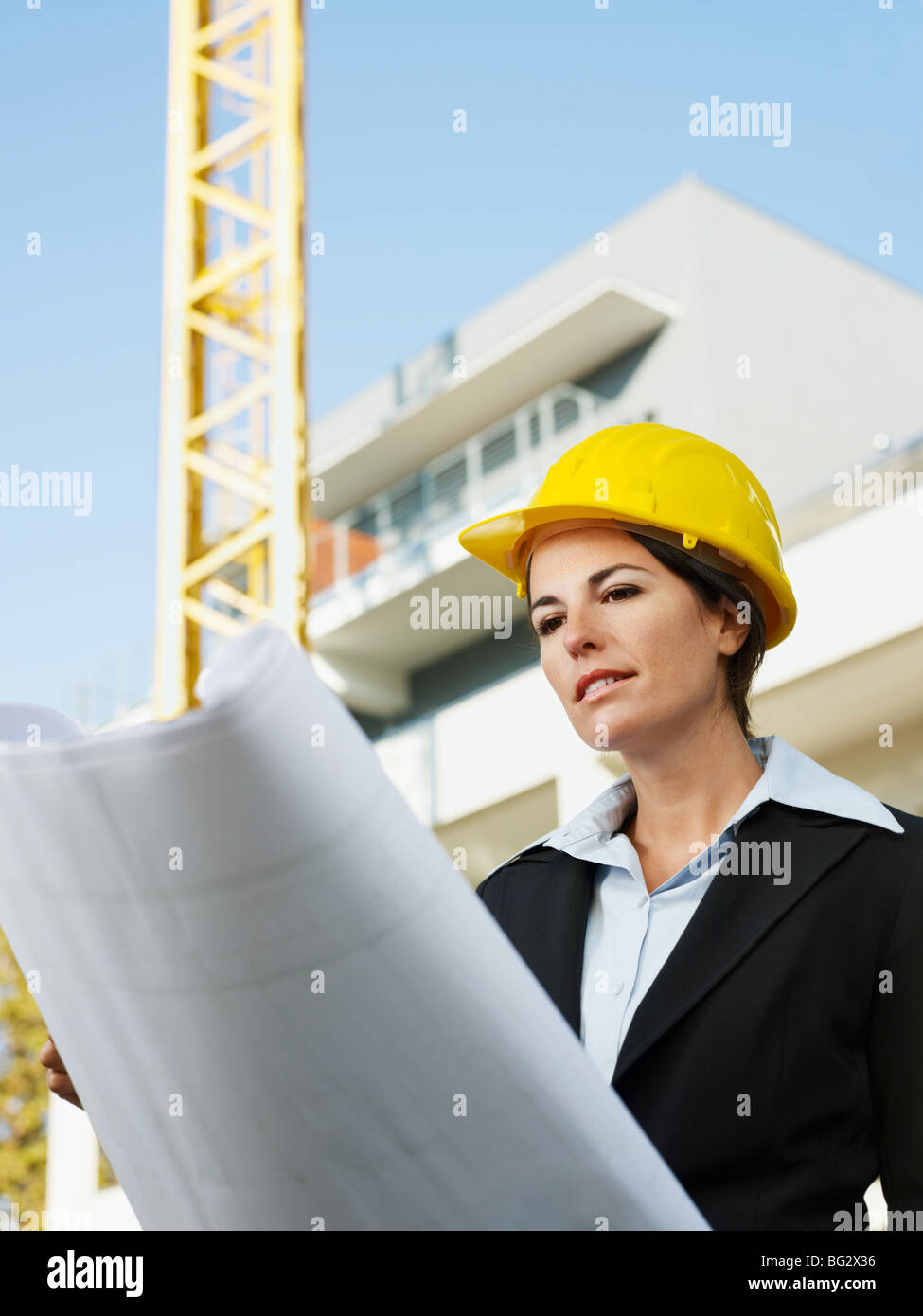 female engineer looking at blueprints in construction site Stock Photo ...