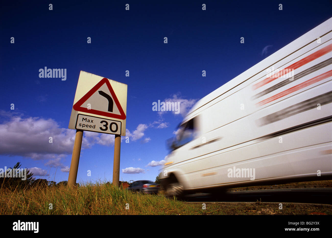van passing warning sign of 30 mph speed limit and sharp left hand bend ...