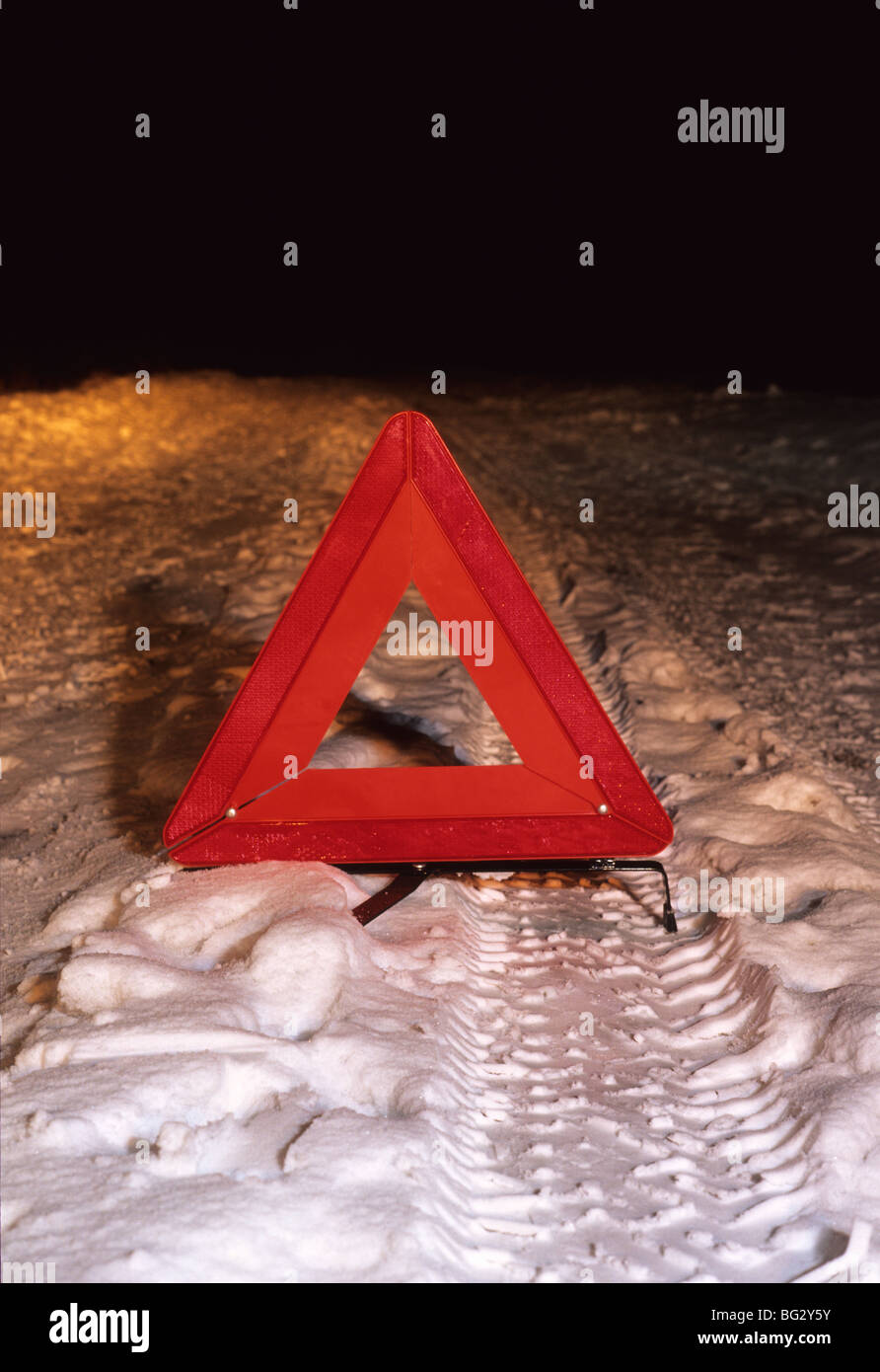 hazard warning triangle on country road in deep winter snow at night ...