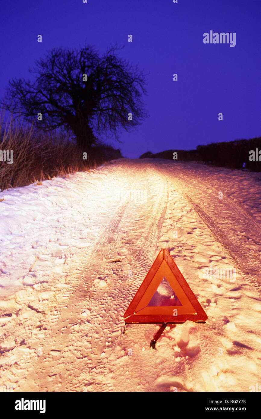 hazard warning triangle on country road in deep winter snow at twilight ...