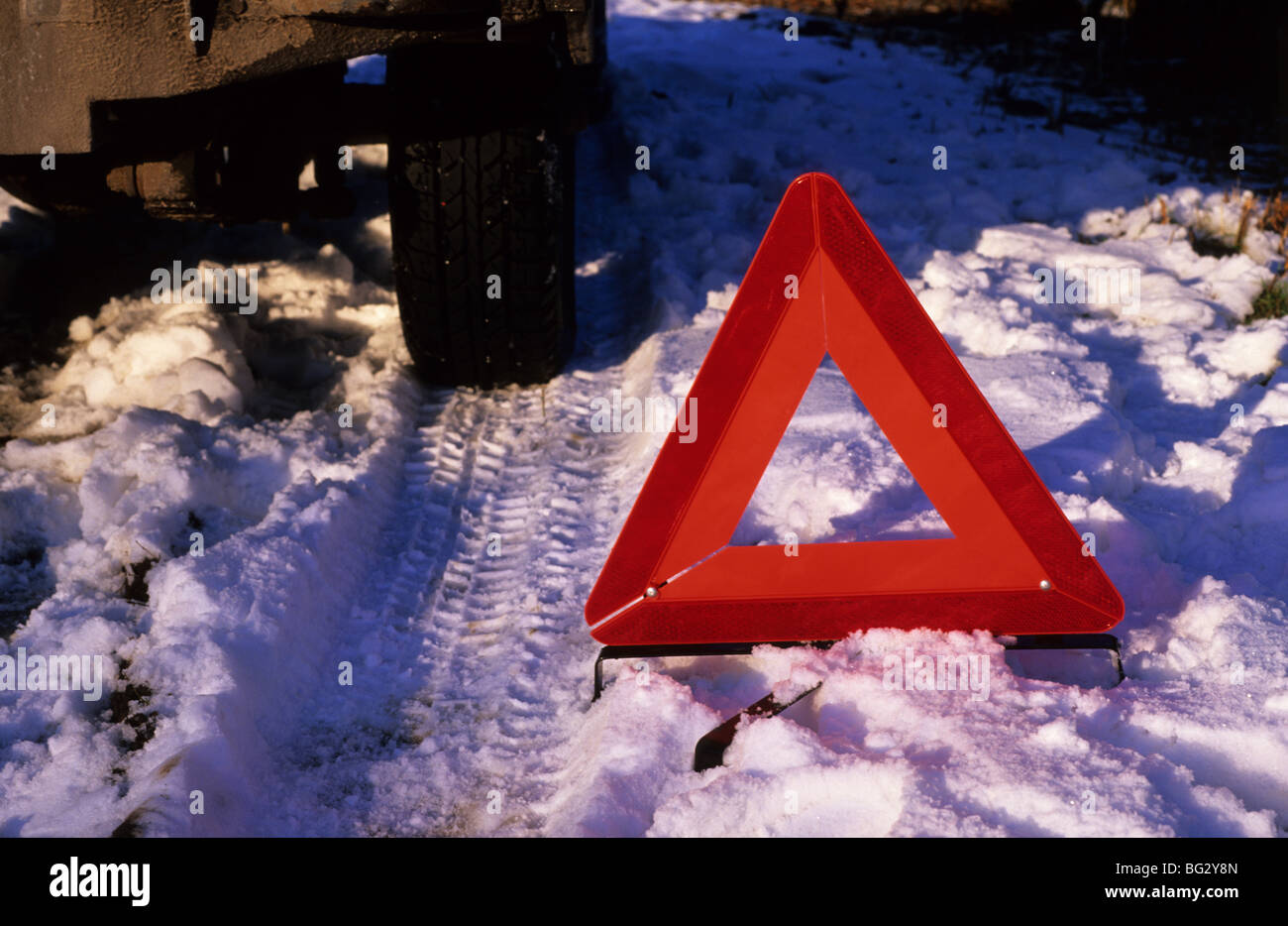 hazard warning triangle by vehicle on country road in deep winter snow ...
