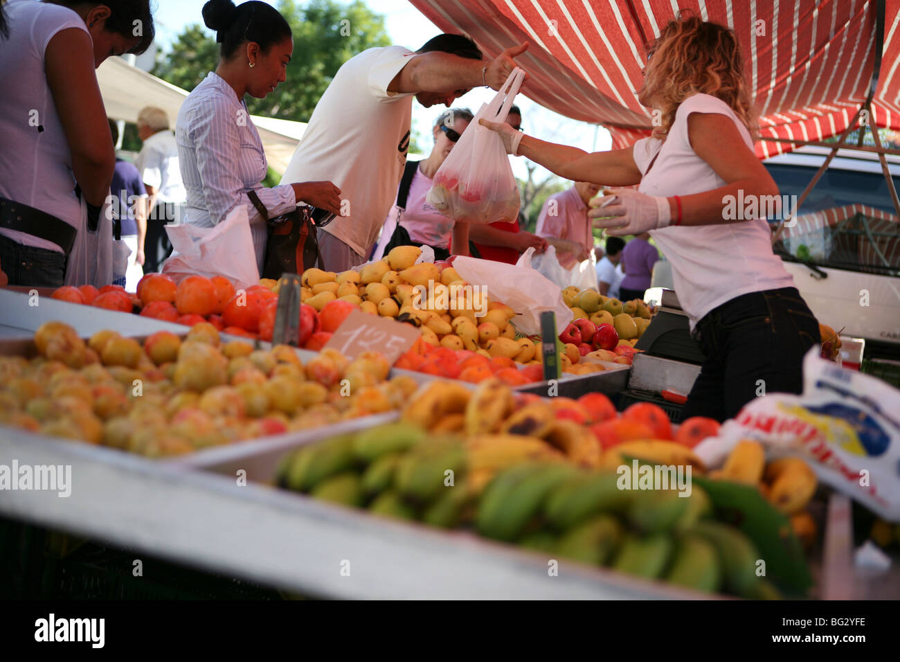 market scene - fruit seller with customers handing over purchases Stock ...