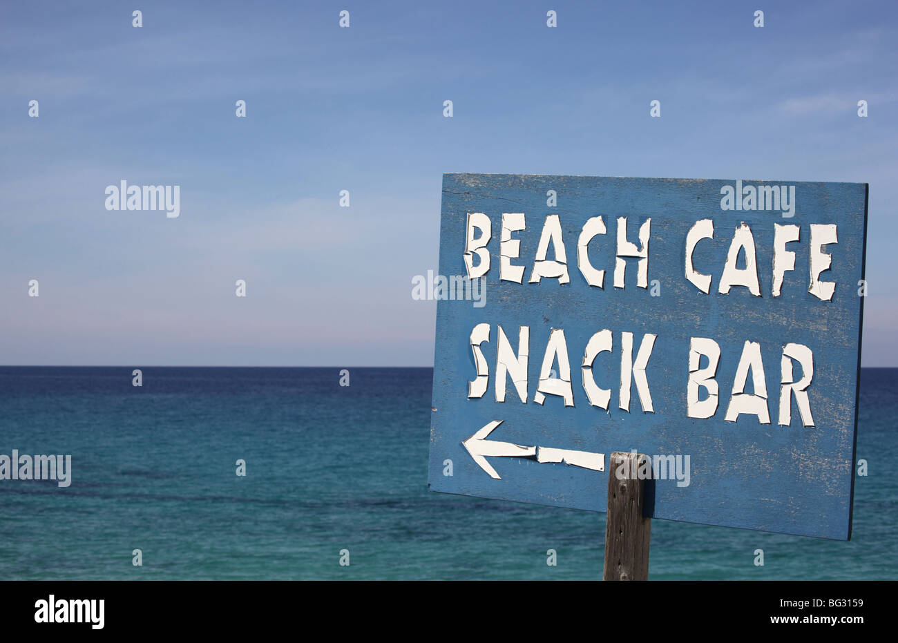 Weather battered sign directing people to a beach cafe and snack bar ...