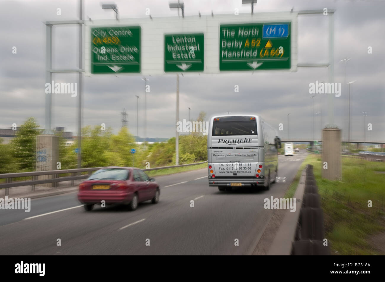 rear view of coach passing under dual carridgeway overhead direction ...