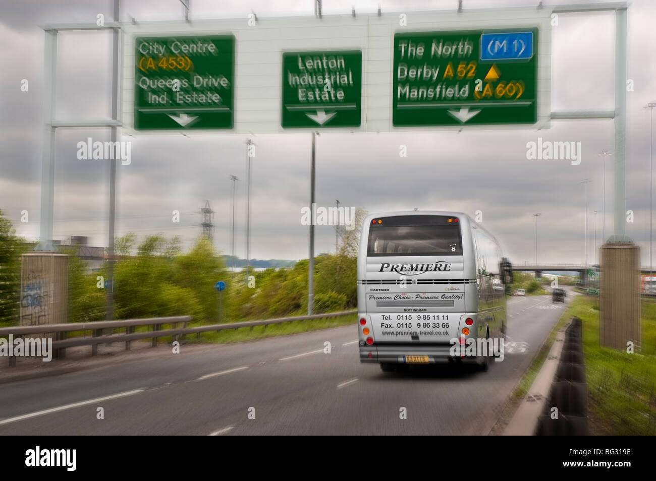 rear view of coach passing under dual carridgeway overhead direction ...