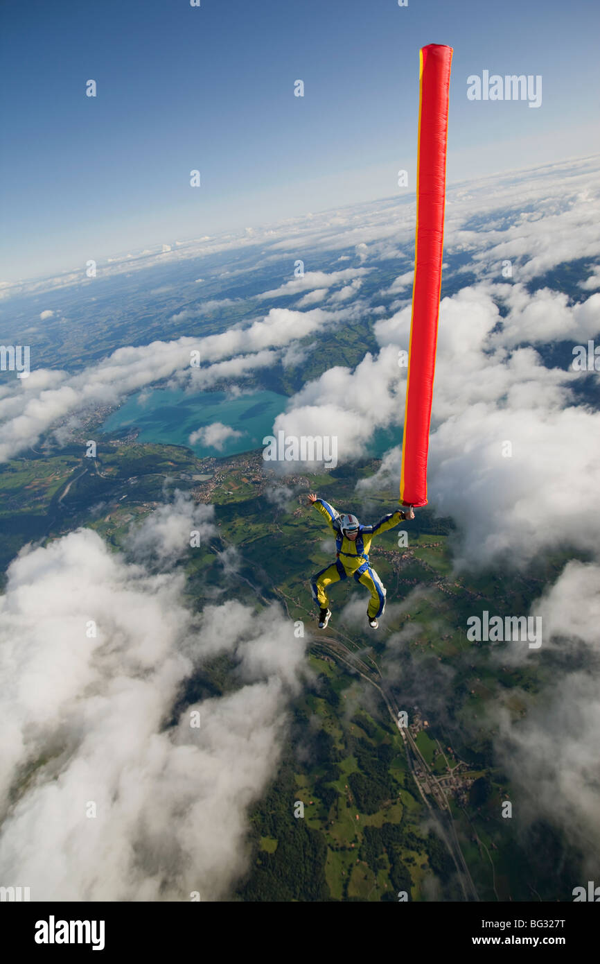 Skydiver with colorful tube is flying over nice land scape. The ...