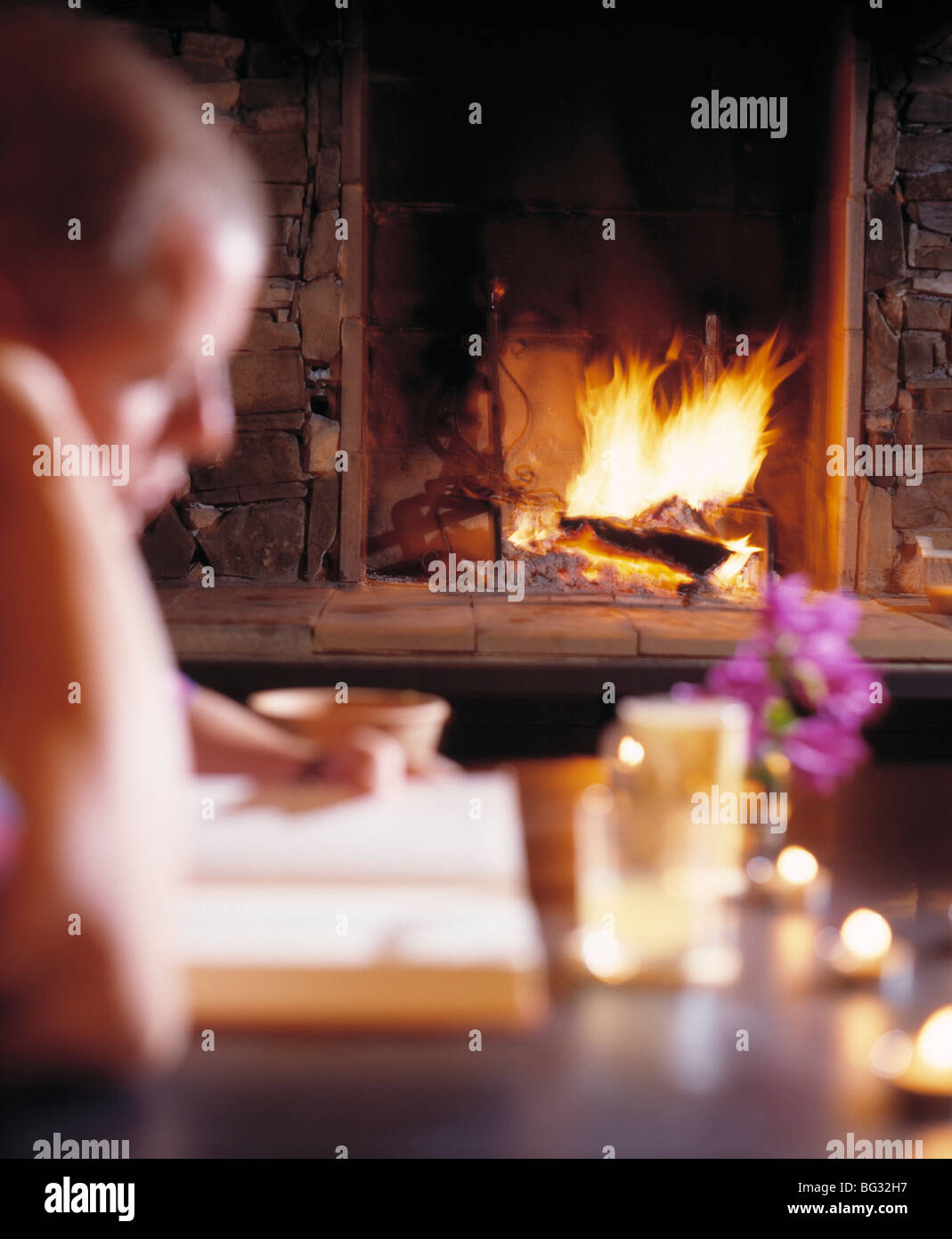 burning fireplace, man reading Stock Photo - Alamy
