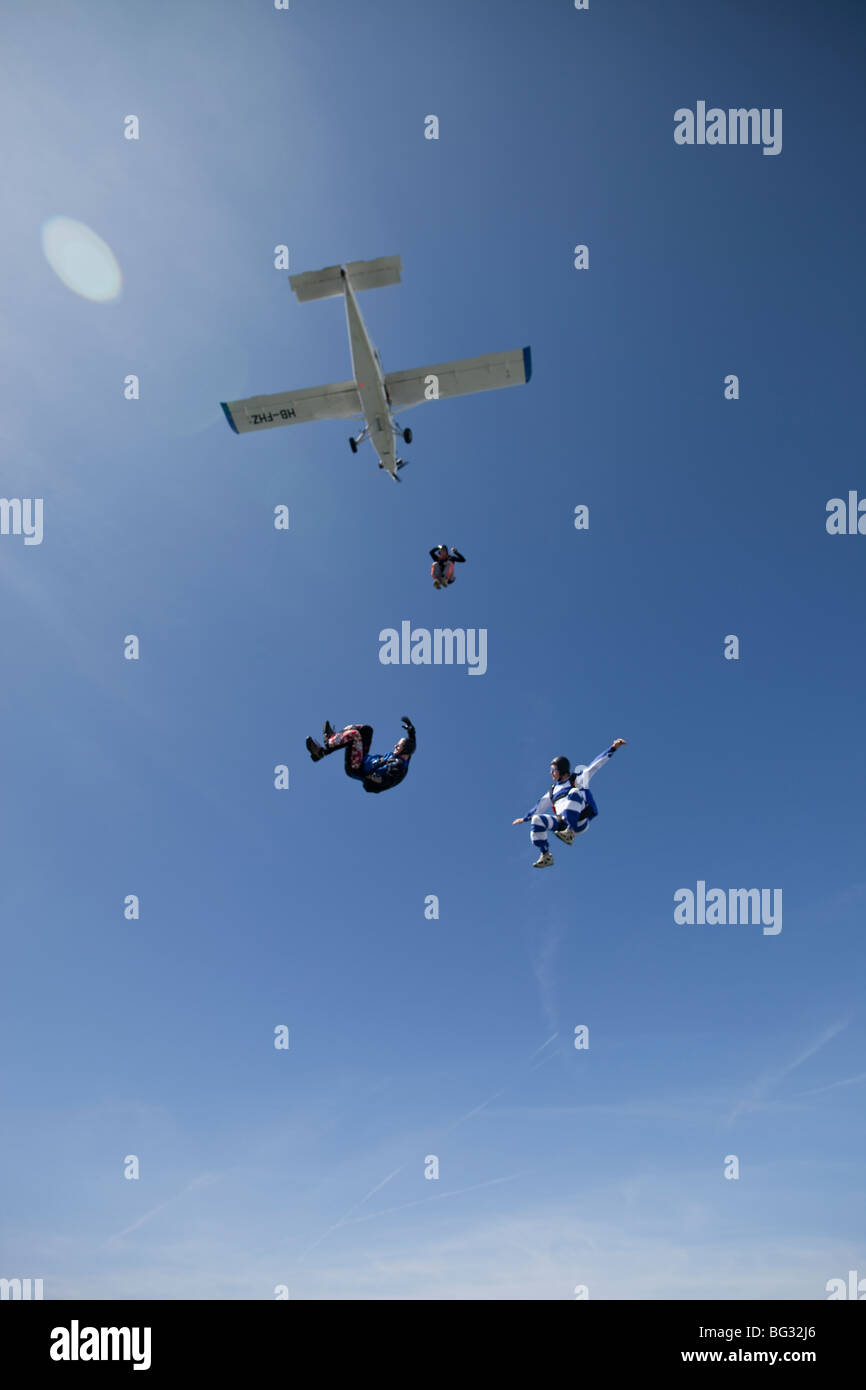 Skydiver are flying head up within a team in the sit fly position and ...