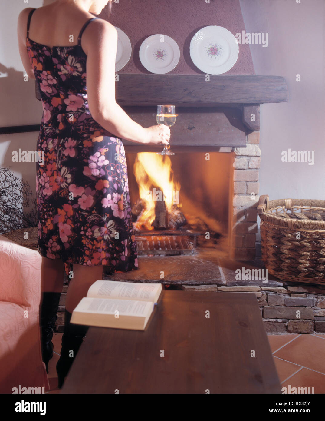 burning fireplace, woman drinking wine Stock Photo - Alamy