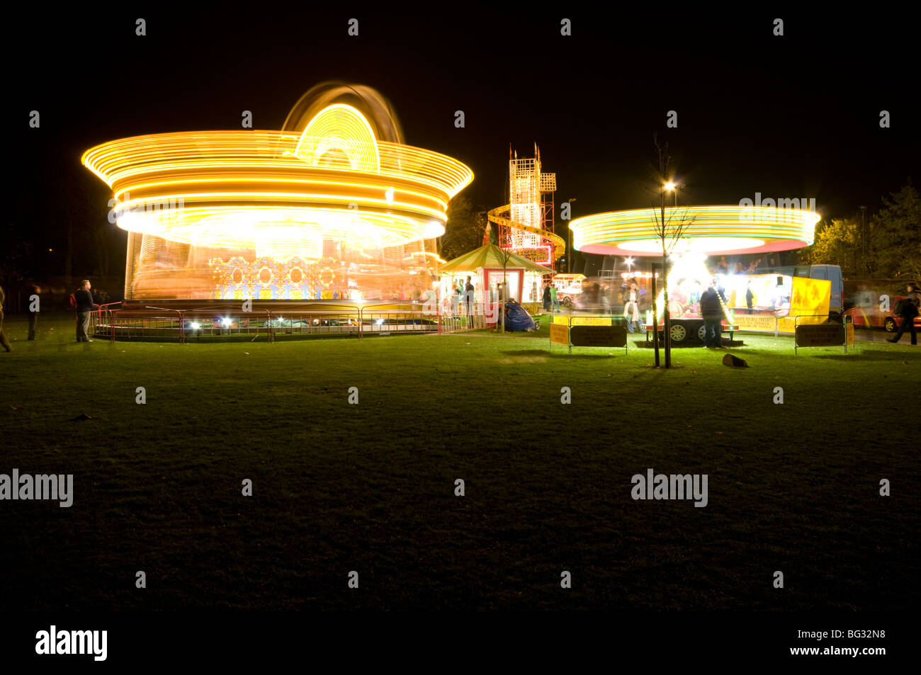 Ferris wheel and Carousel lit up at night at a funfair in Chesterfield ...