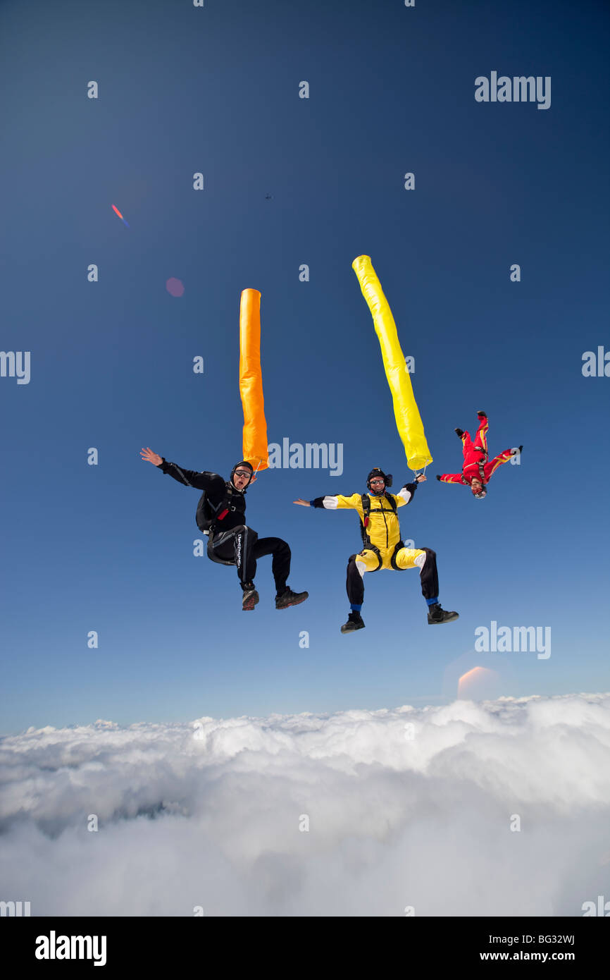 Skydivers with colorful tubes flying over cloud base. The Freeflyers ...