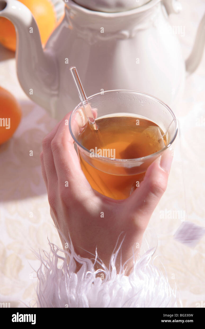 Hand holding hot glass of tea Stock Photo - Alamy