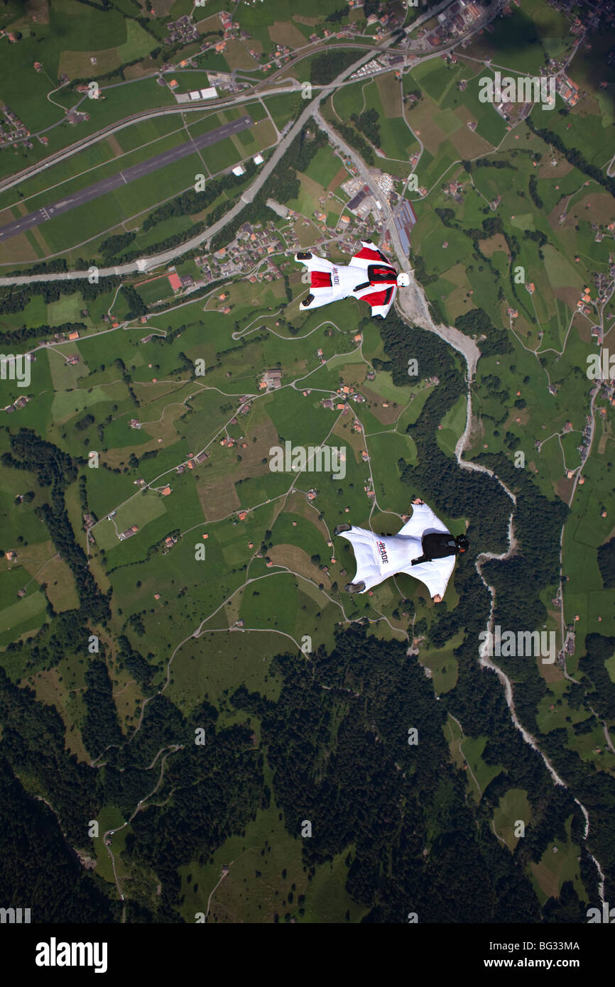 Skydivers with wings between the arms and legs are flying in a ...