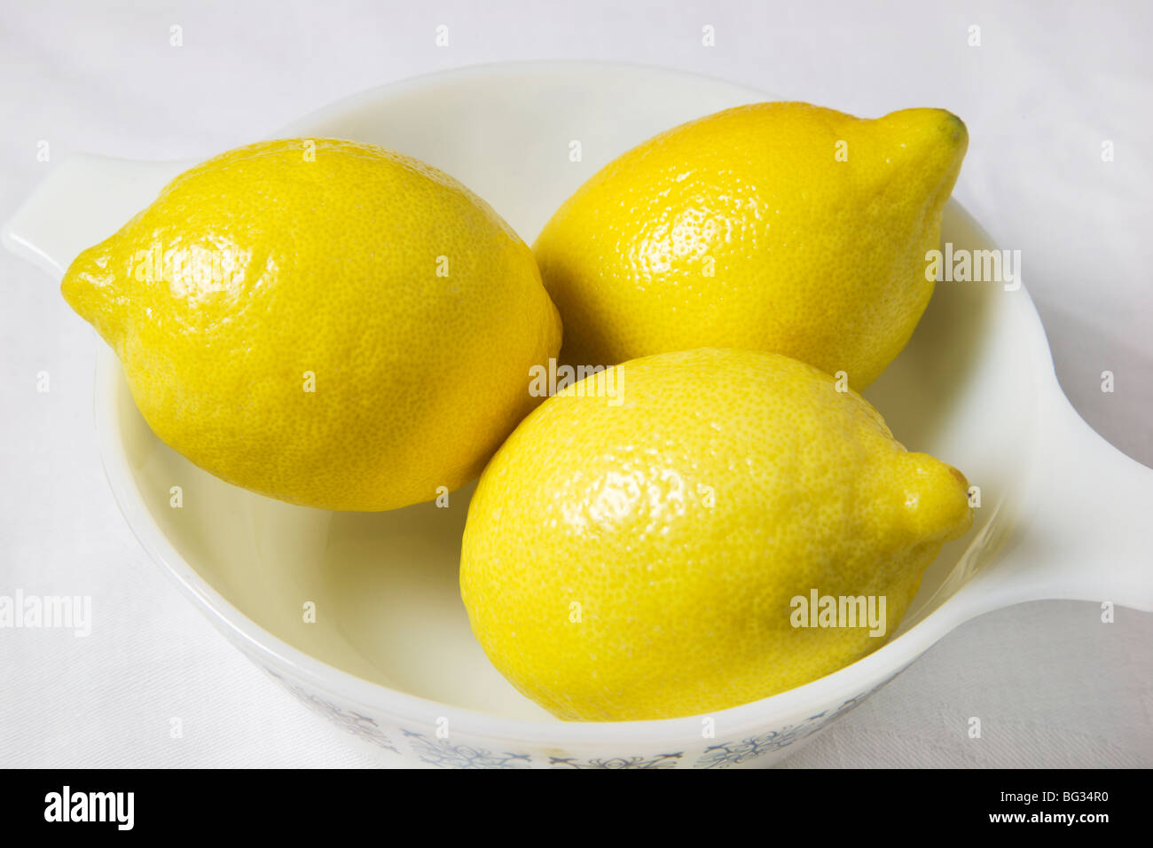 Three Lemons in a White Dish Stock Photo - Alamy