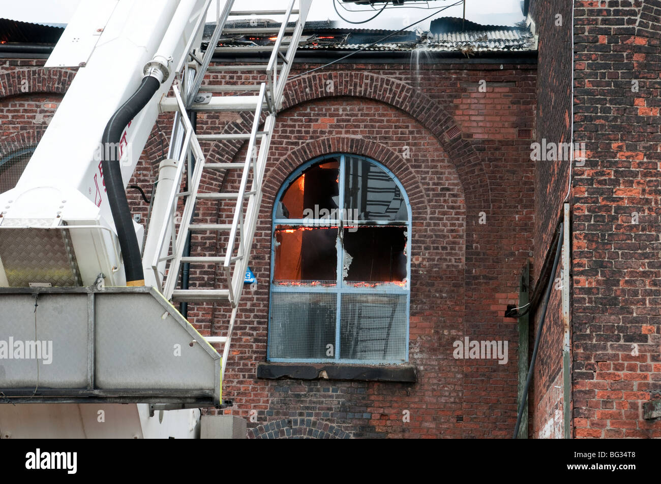 Flames at broken window of building on fire Stock Photo - Alamy