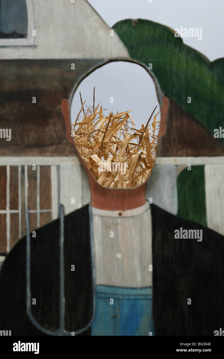 Painting of American Gothic with cut out face in front of corn field ...