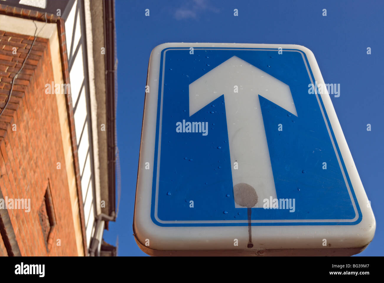 british one-way street sign, with white arrow on blue background, with ...