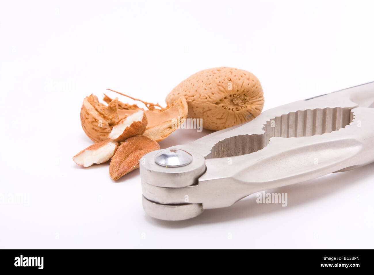 Almond nut cracked open with nut cracker isolated against white ...