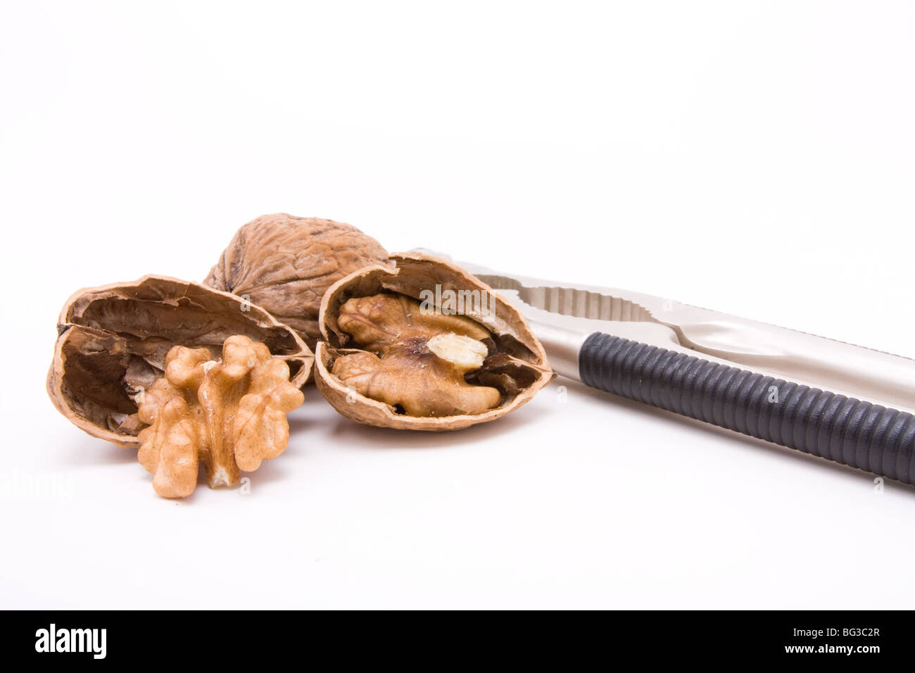 Walnut cracked open with nut cracker isolated against white background ...