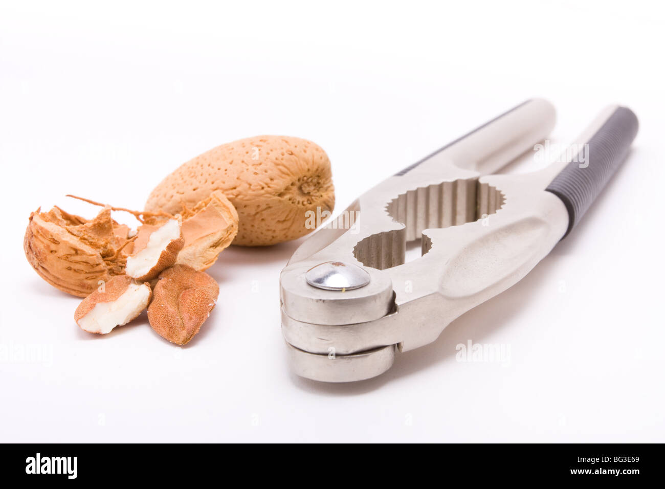 Almond nut cracked open with nut cracker isolated against white ...