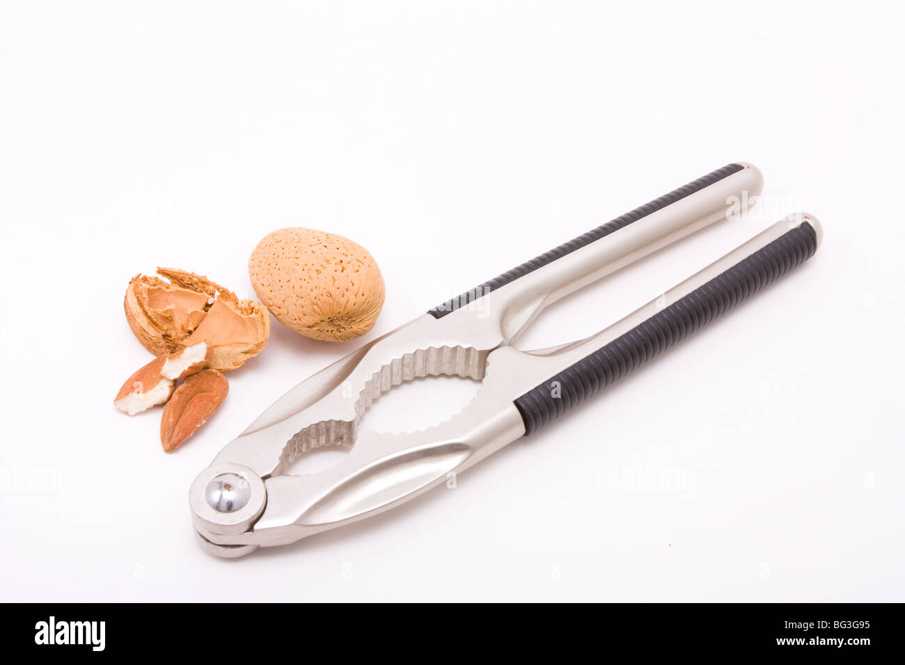 Almond nut cracked open with nut cracker isolated against white ...