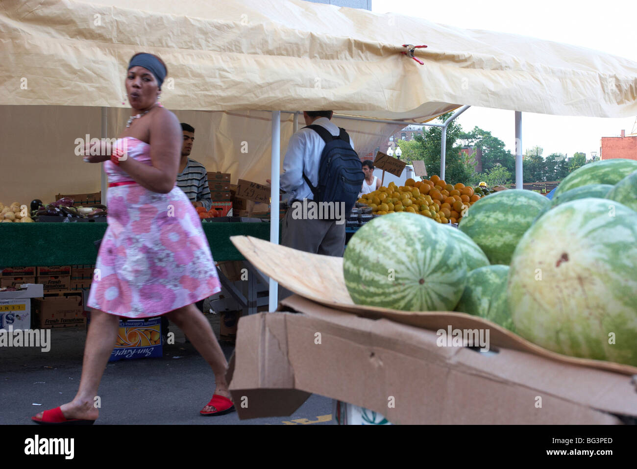 A woman walking past watermelons in the outdoor market in Boston Stock ...