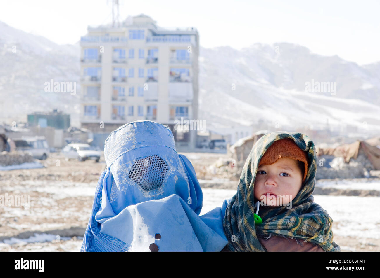 Afghan mother holding her son in the winter, Kabul city, Afghanistan ...