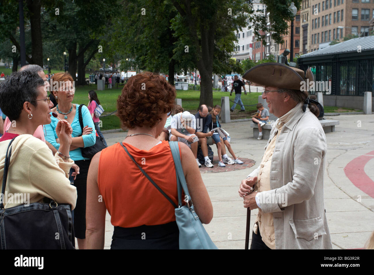 A group of tourists talking to a reenactor dressed as Ben Franklin ...