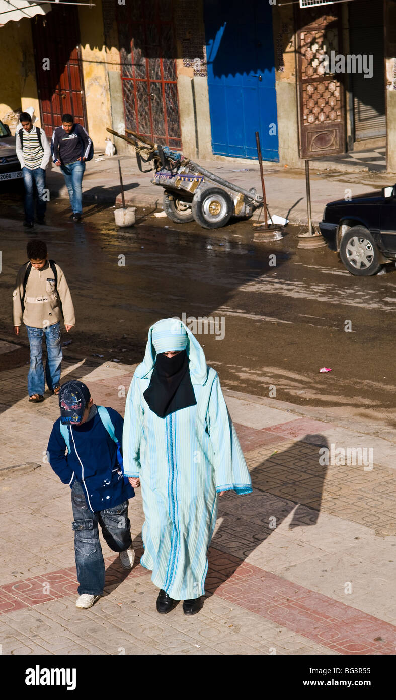 A veiled woman walks the street of the old city of Meknes Stock Photo ...