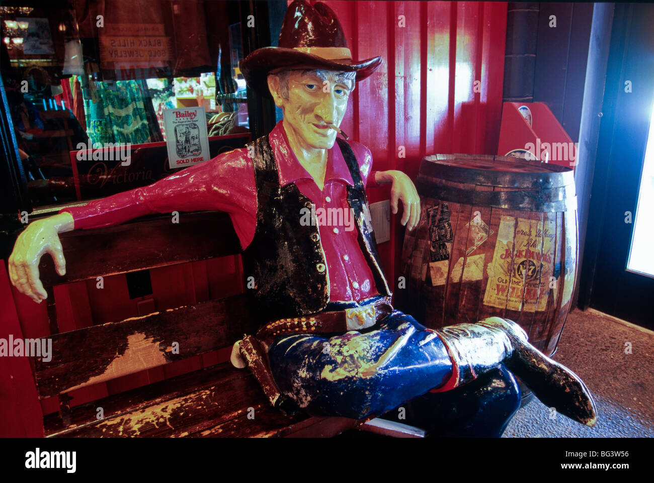 Lifesize cowboy figure sitting on a bench in Wall Drug Store, well ...