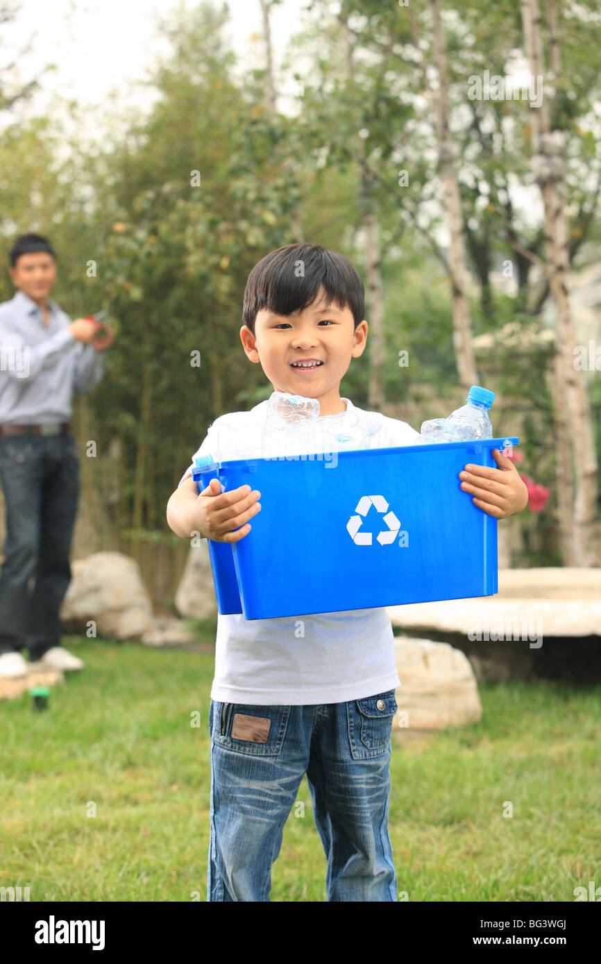 Two boys carrying recycling container hi-res stock photography and ...