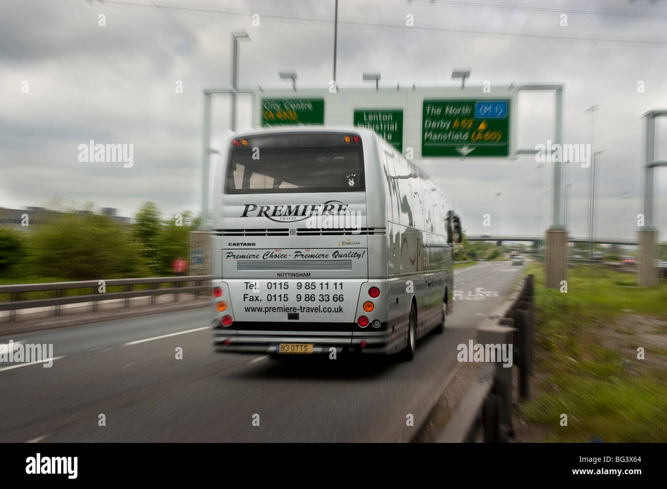 rear view of coach passing under dual carridgeway overhead direction ...