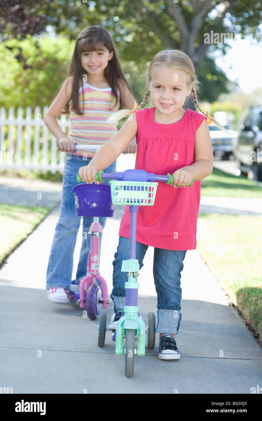 Two girls riding scooter people hi-res stock photography and images - Alamy