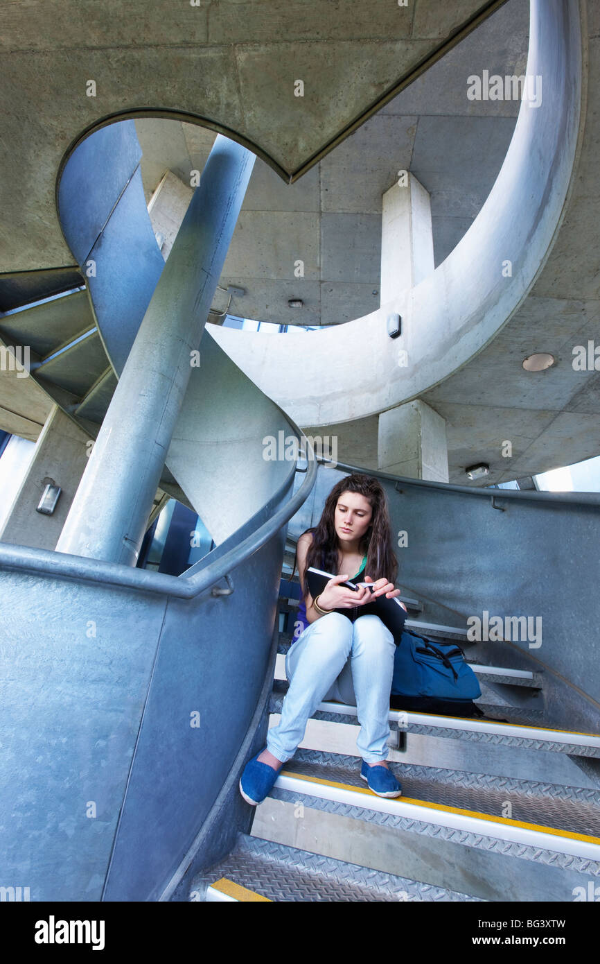 University student reading on staircase Stock Photo - Alamy