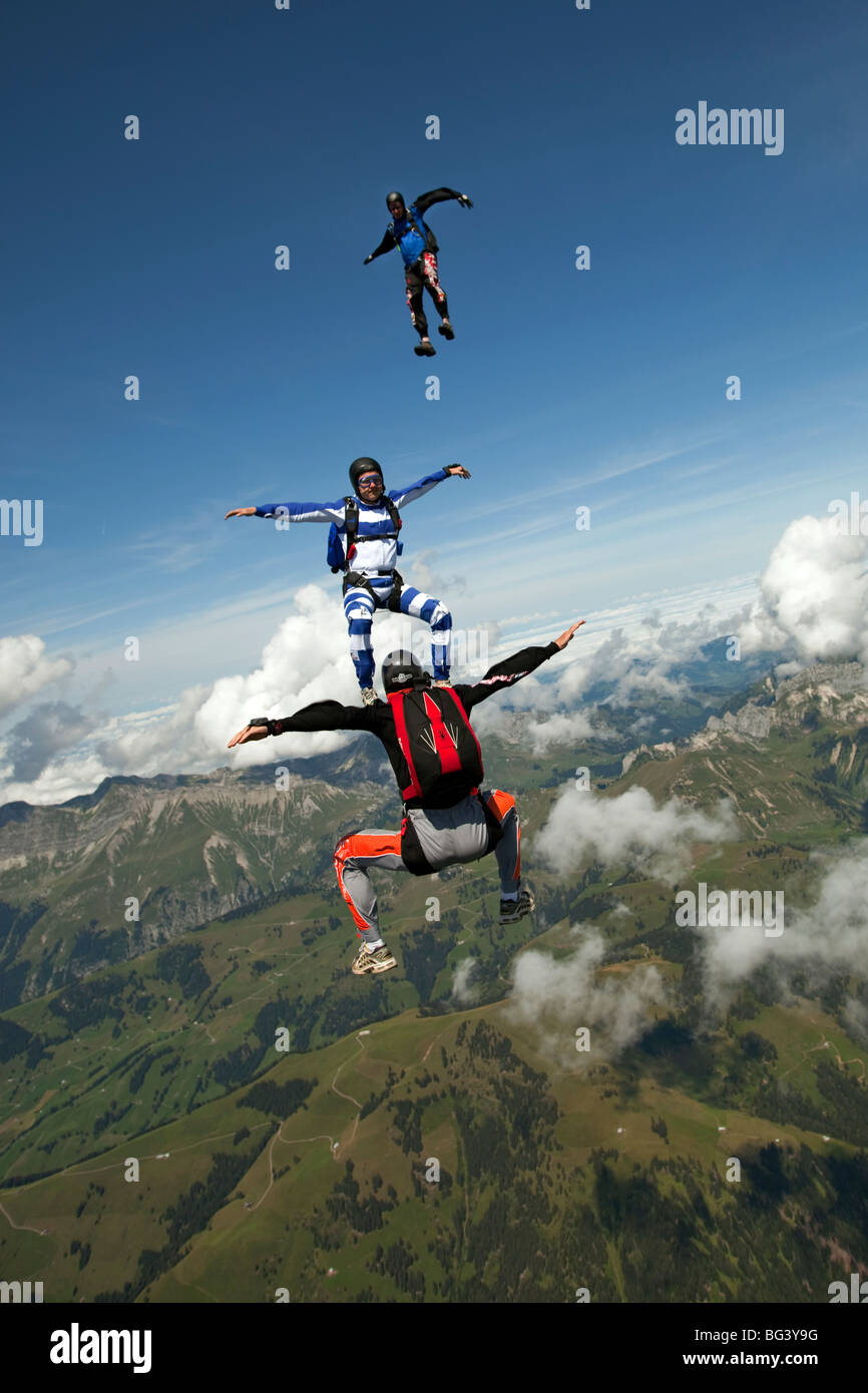 Skydiver are flying head up within a team in the sit fly position over ...