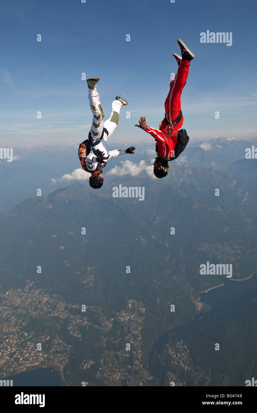Skydivers are flying head down and try to holding each other. In this ...